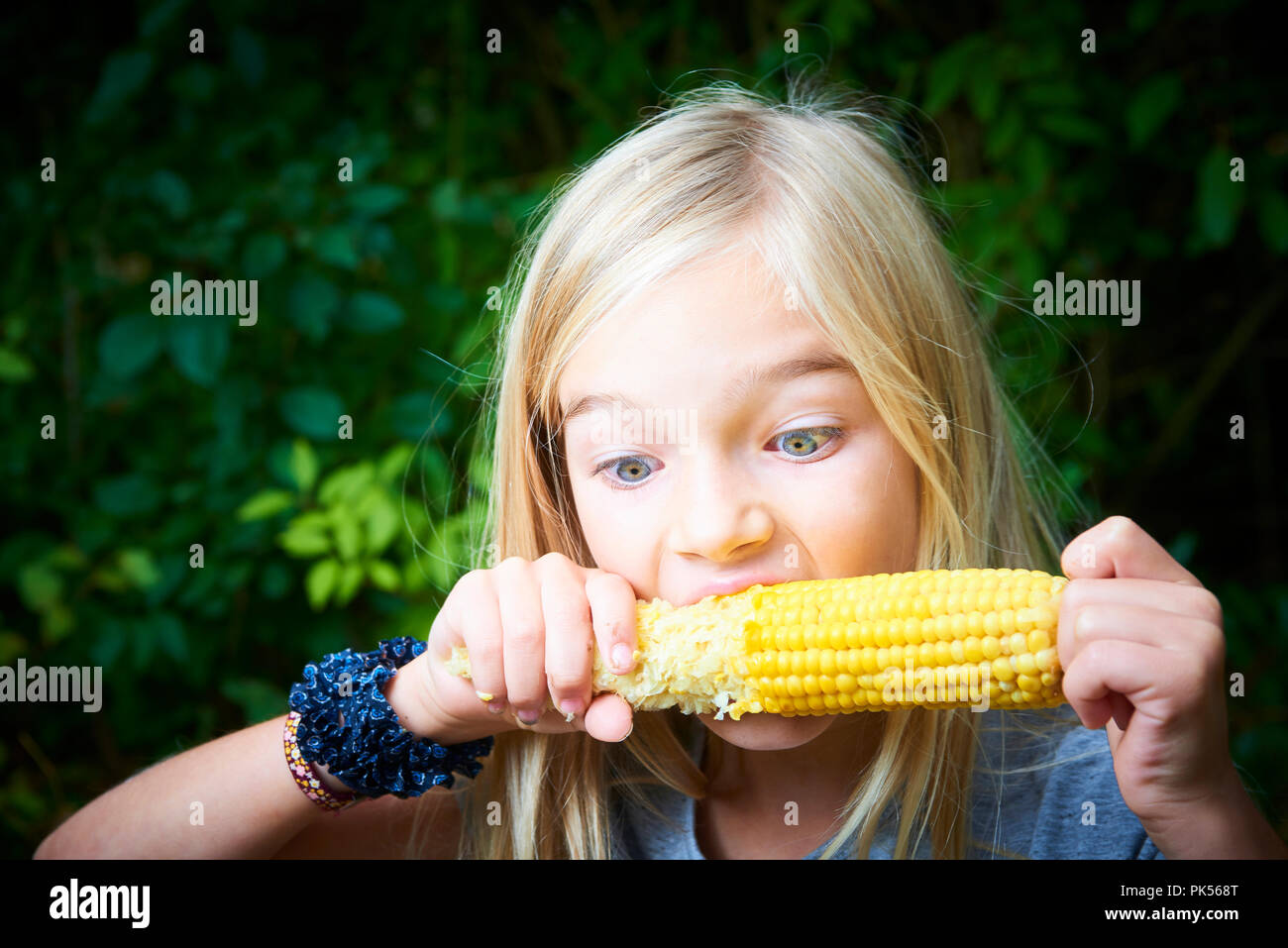 Portrait of girl eating sweet boiled sweet corn outdoor Stock Photo - Alamy