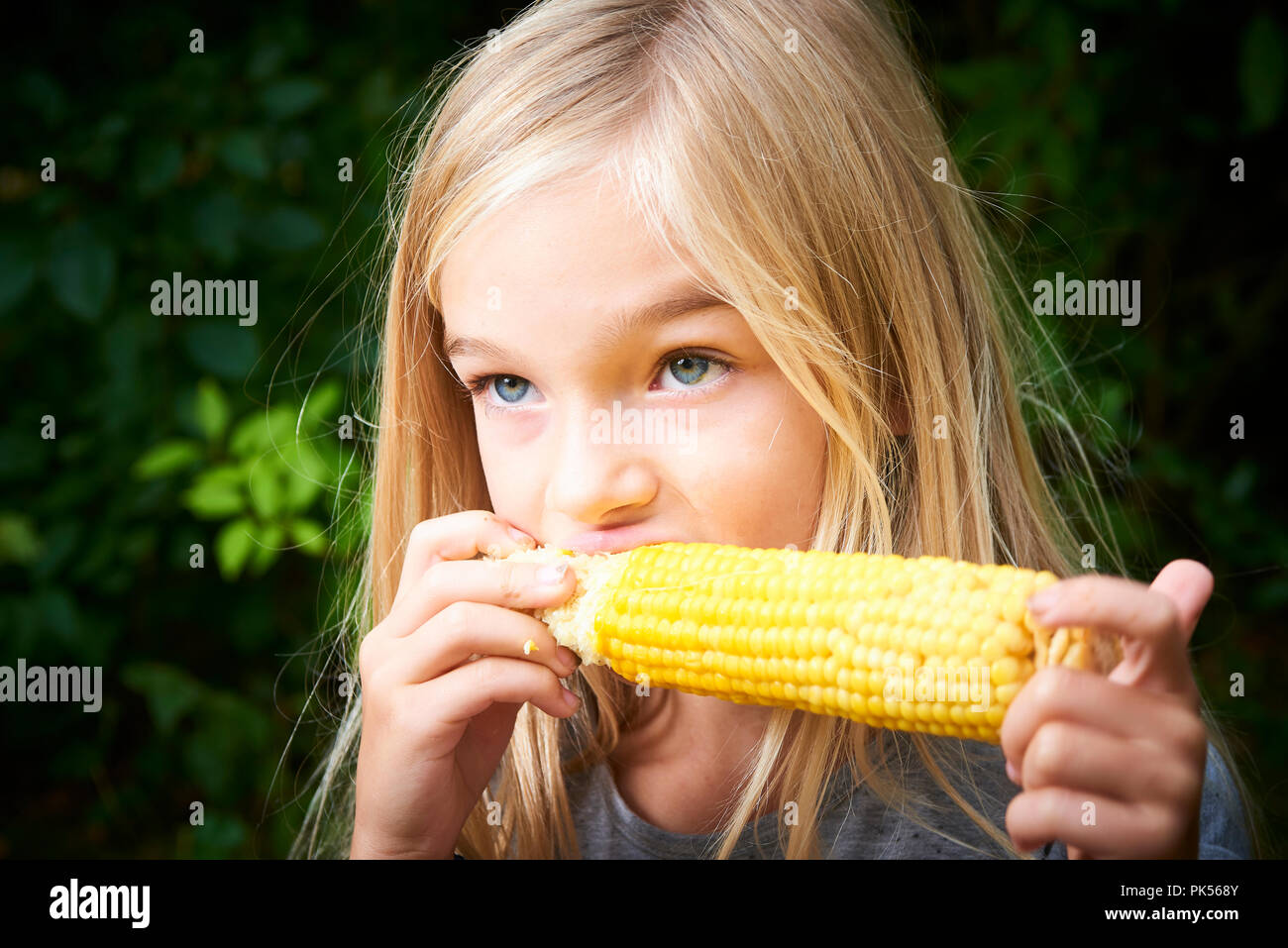 Portrait of girl eating sweet boiled sweet corn outdoor Stock Photo - Alamy