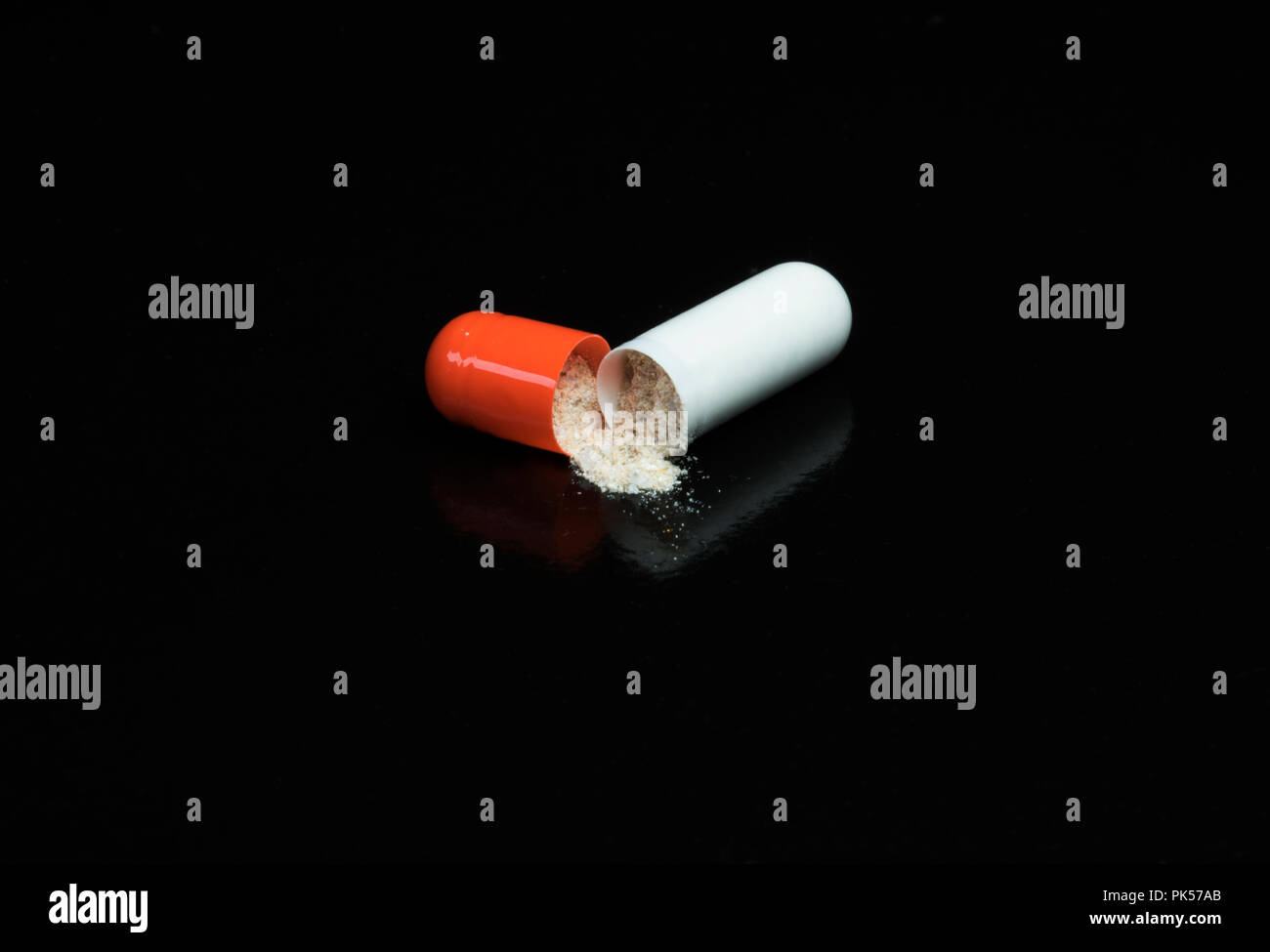 Split open diet pill. Two color prescription medication spilled on a ...