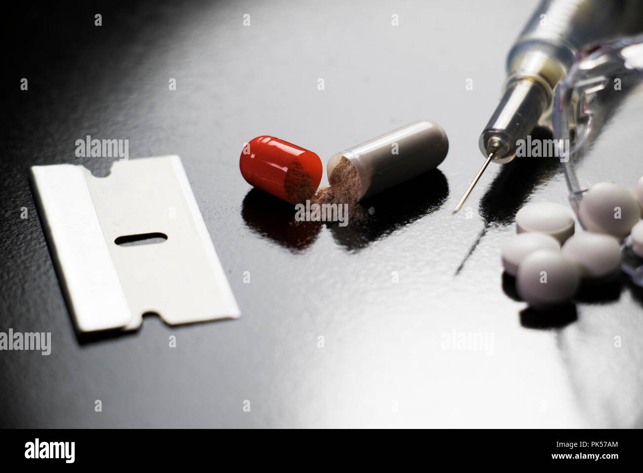 Drug epidemic needles,pills, razor blade on black background. Isolated ...