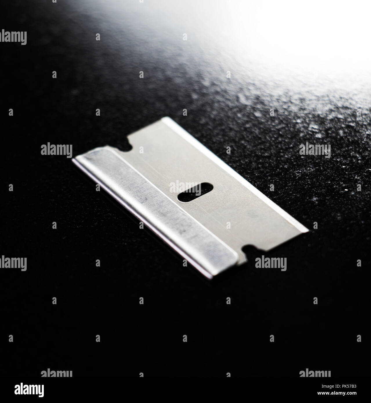 Razor blade isolated on black shinny background Stock Photo - Alamy