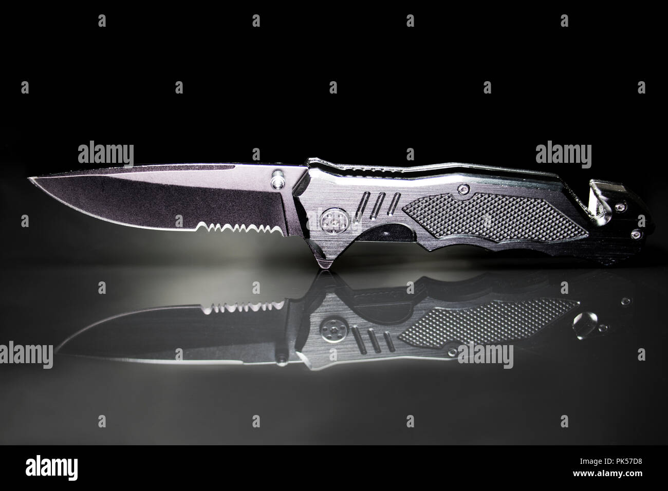 Black tactical knife reflecting on glass. Macro of an army knife with a ...