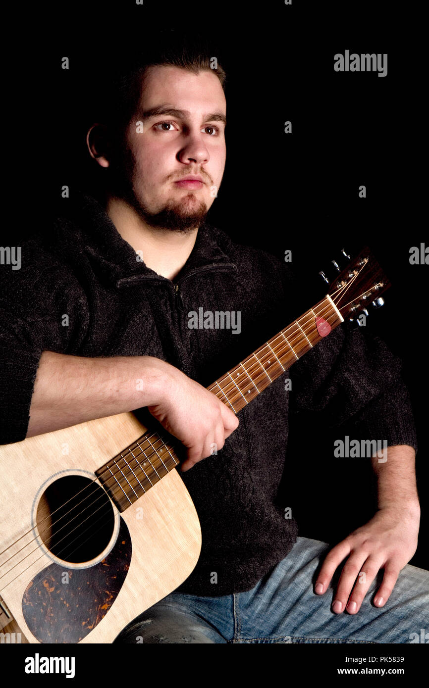 Young musician male with his acoustic guitar portrait Stock Photo - Alamy