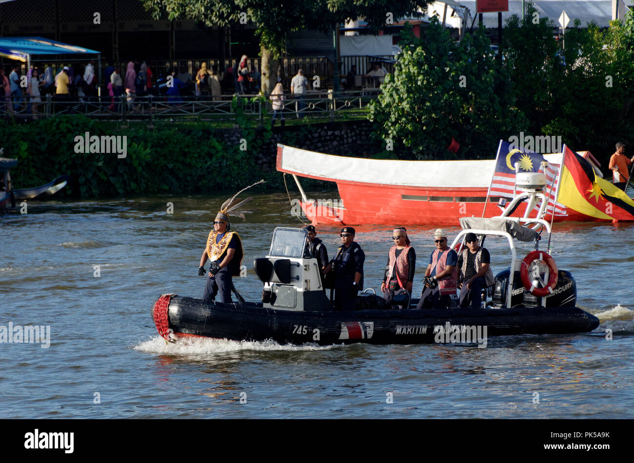 Kuching, Sarawak river, boats with natives in traditional dress form ...