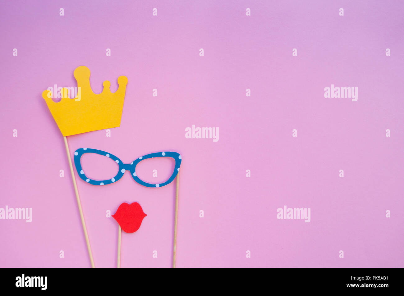 Colorful photo booth props glasses, lips, crown and on pink background ...