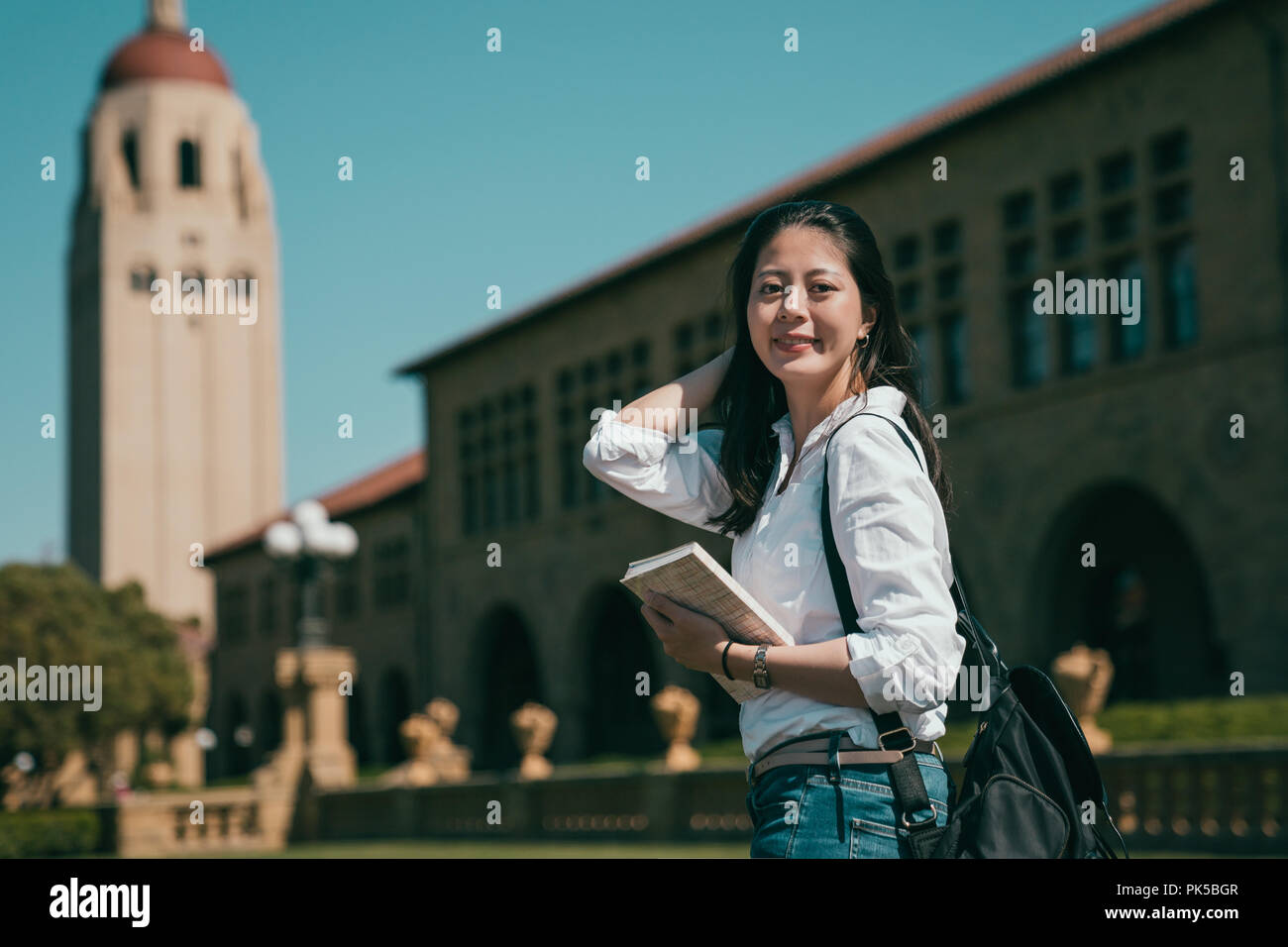 smart and beautiful asian student holding her book and visiting her ...