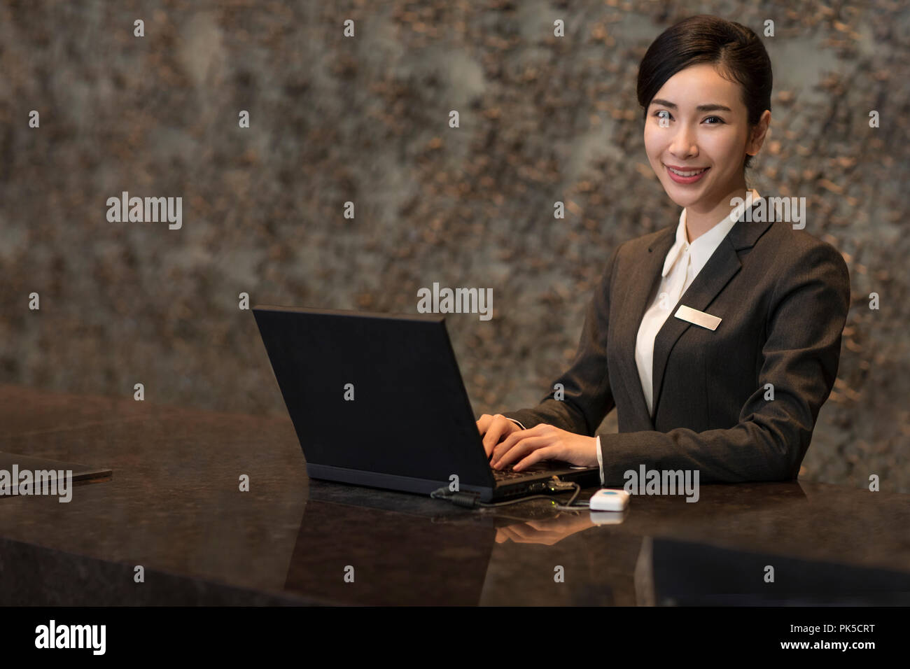 Cheerful hotel receptionist Stock Photo - Alamy