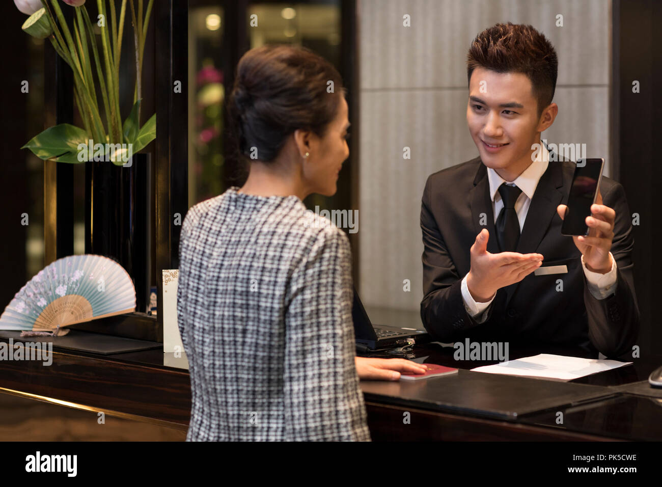 Elegant woman checking into hotel Stock Photo - Alamy