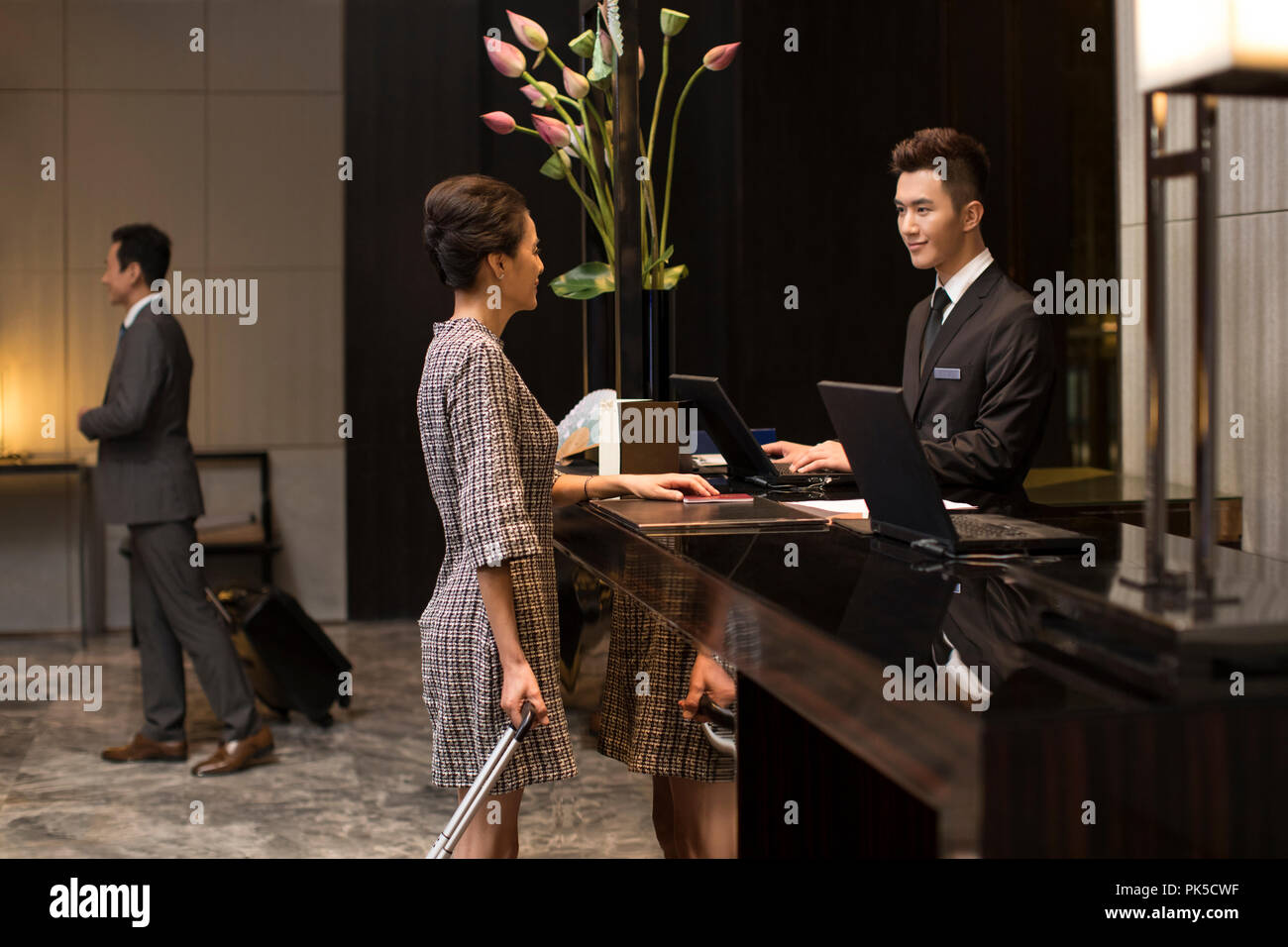 Elegant woman checking into hotel Stock Photo - Alamy