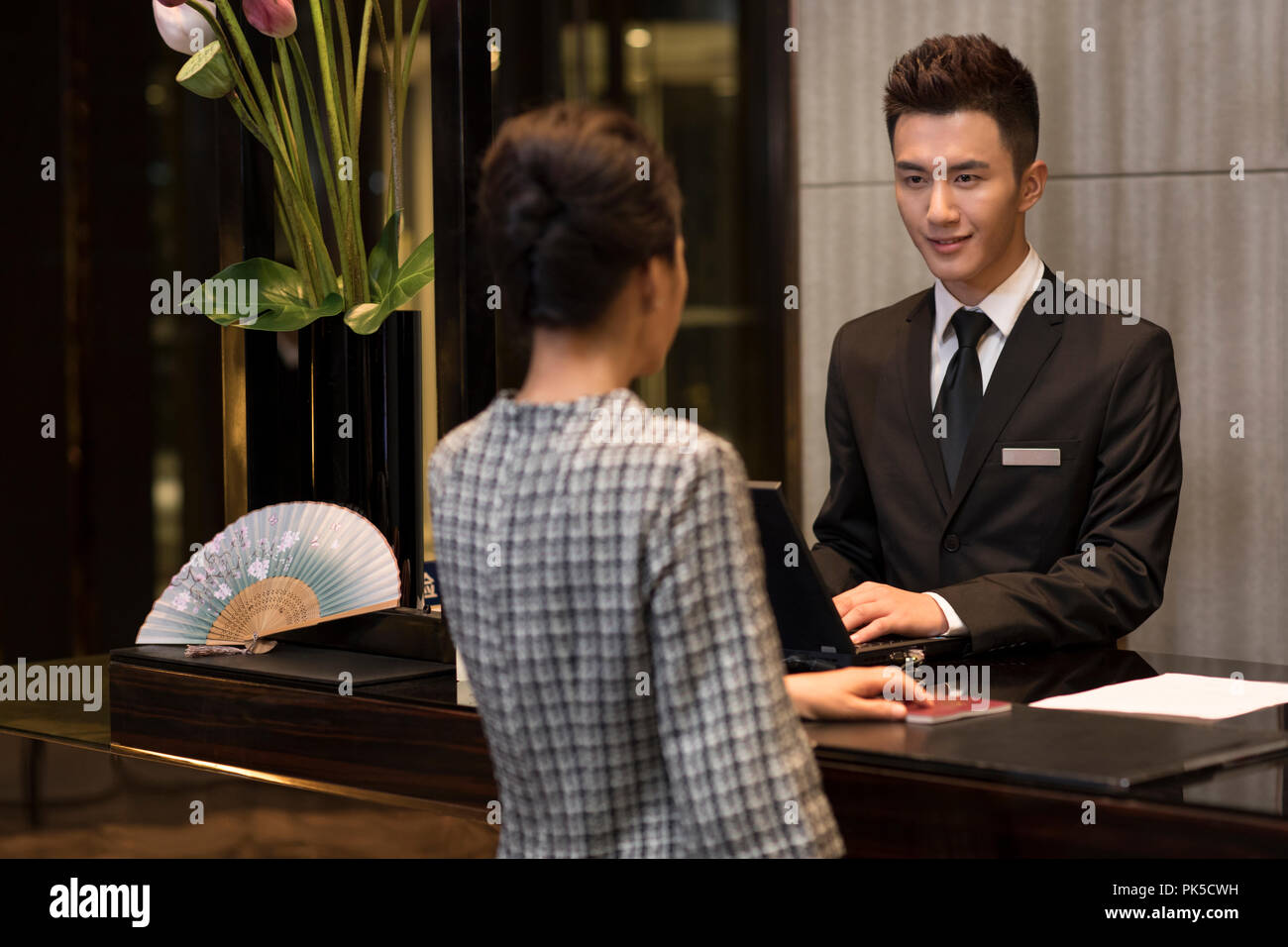Elegant woman checking into hotel Stock Photo - Alamy