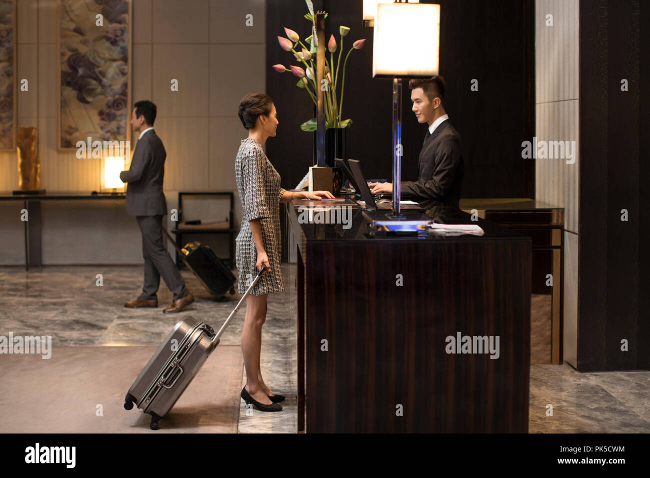 Elegant woman checking into hotel Stock Photo - Alamy