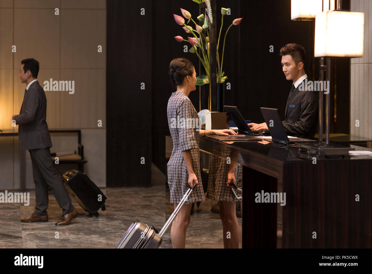 Elegant woman checking into hotel Stock Photo - Alamy
