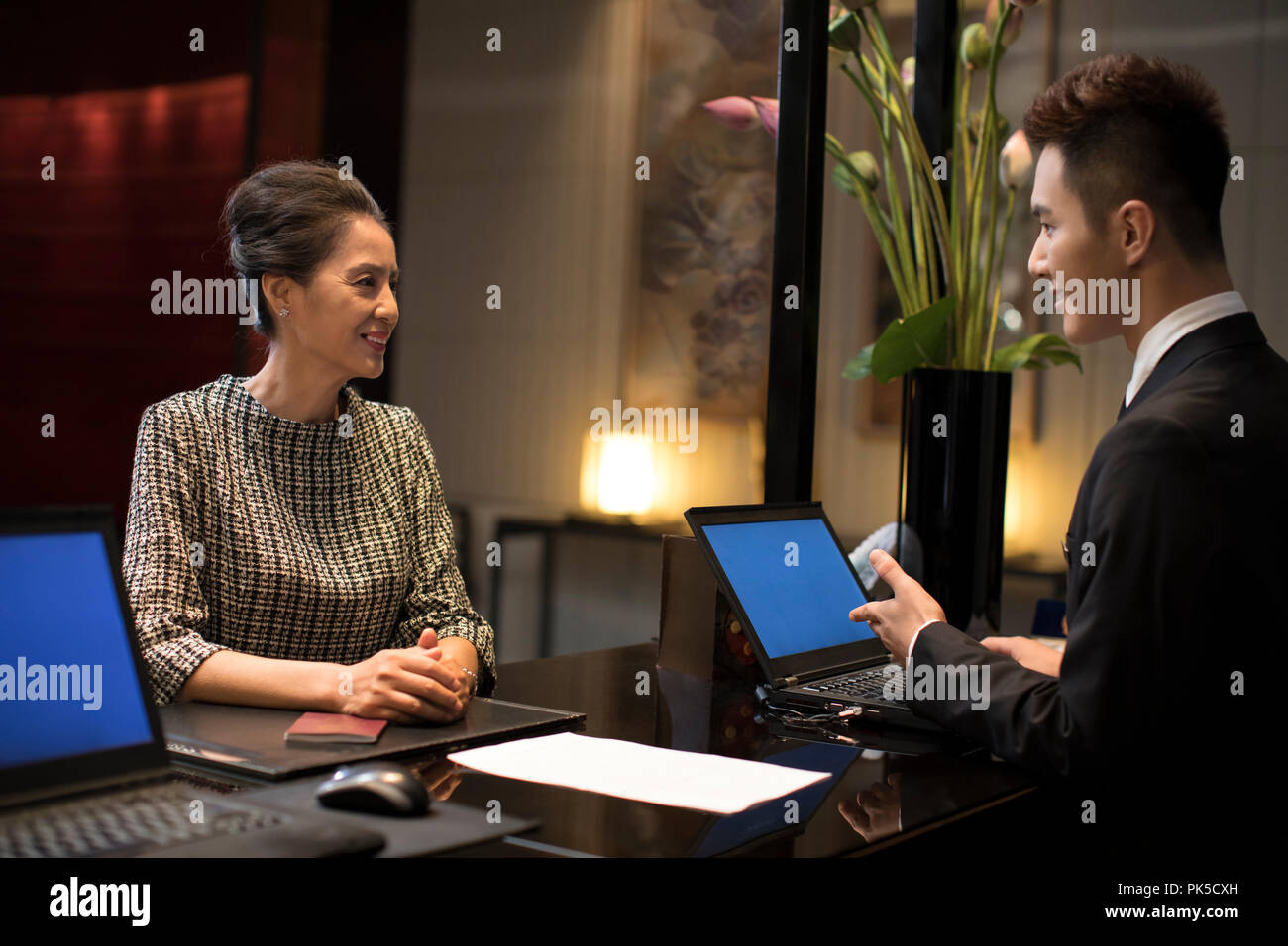 Elegant woman checking into hotel Stock Photo - Alamy