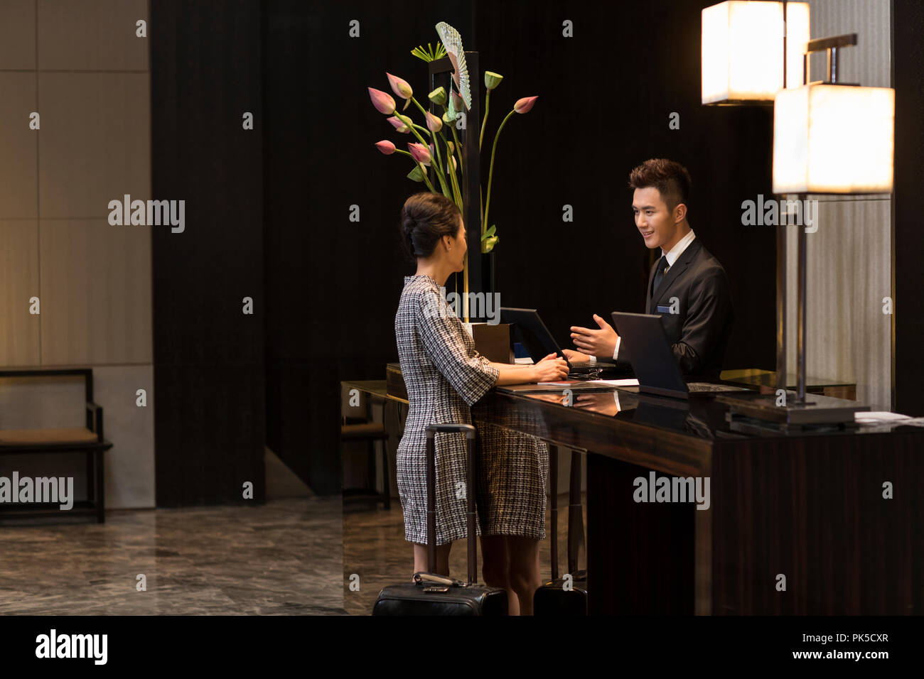 Elegant woman checking into hotel Stock Photo - Alamy