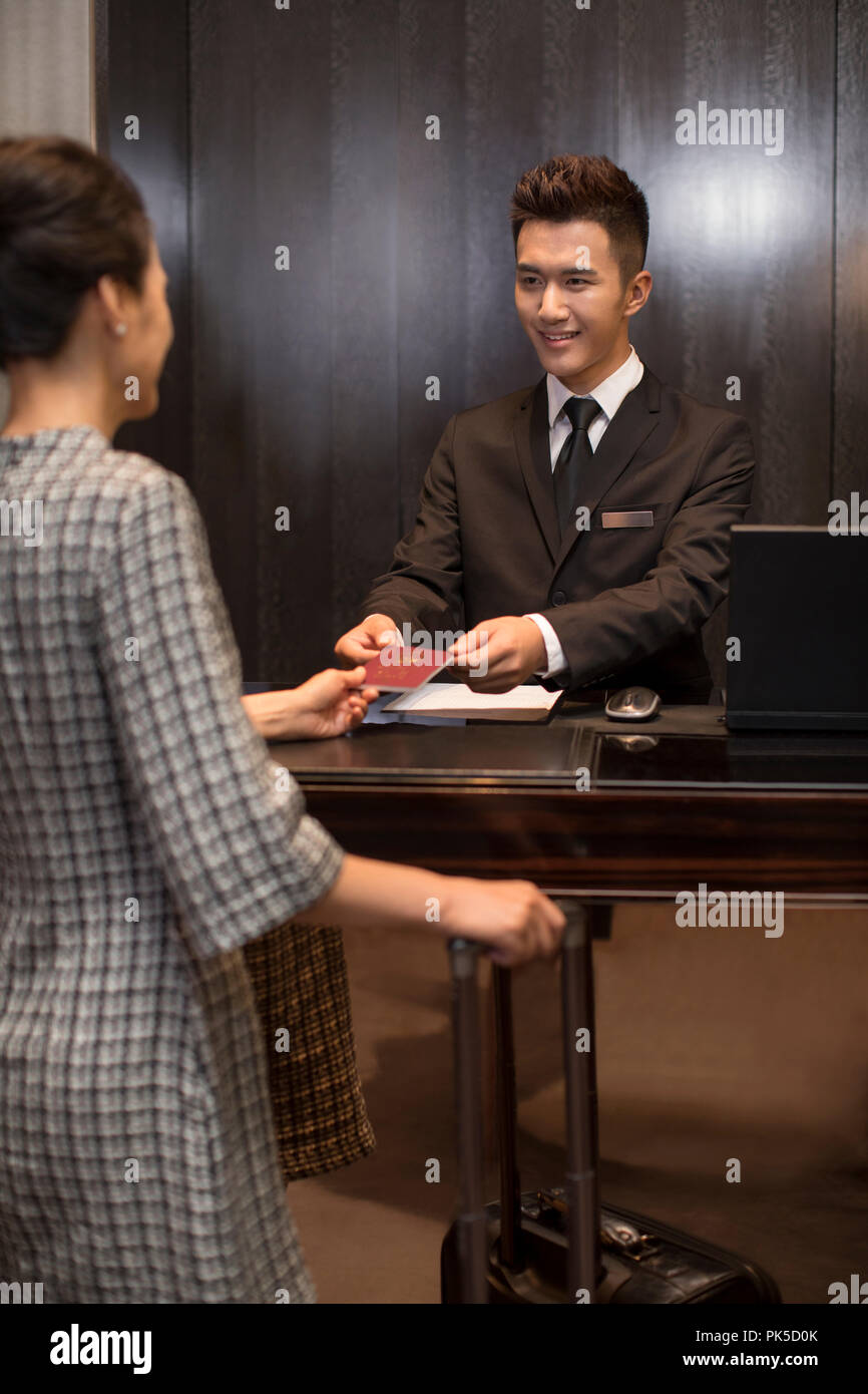 Elegant woman checking into hotel Stock Photo - Alamy