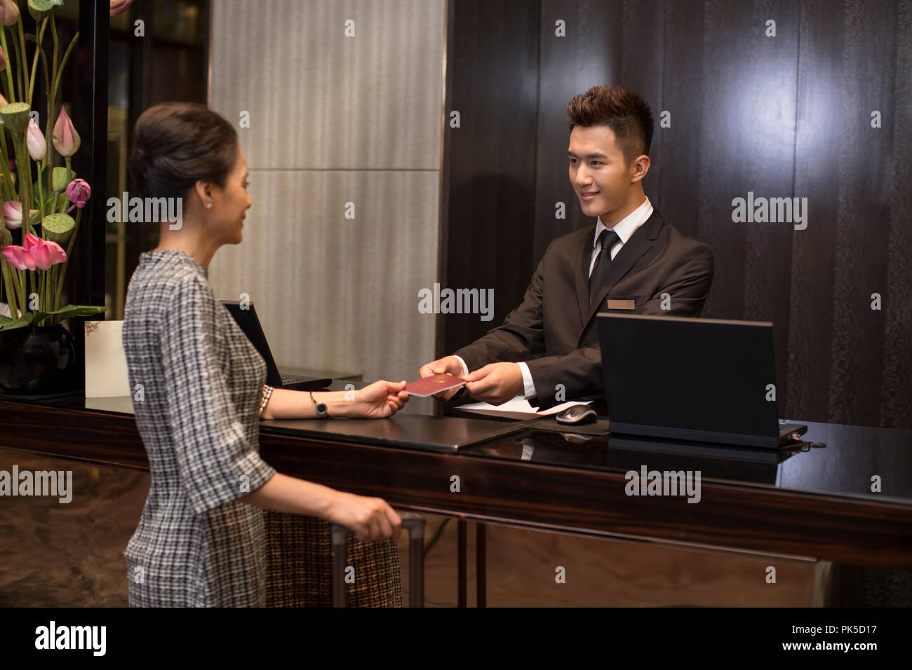 Elegant woman checking into hotel Stock Photo - Alamy