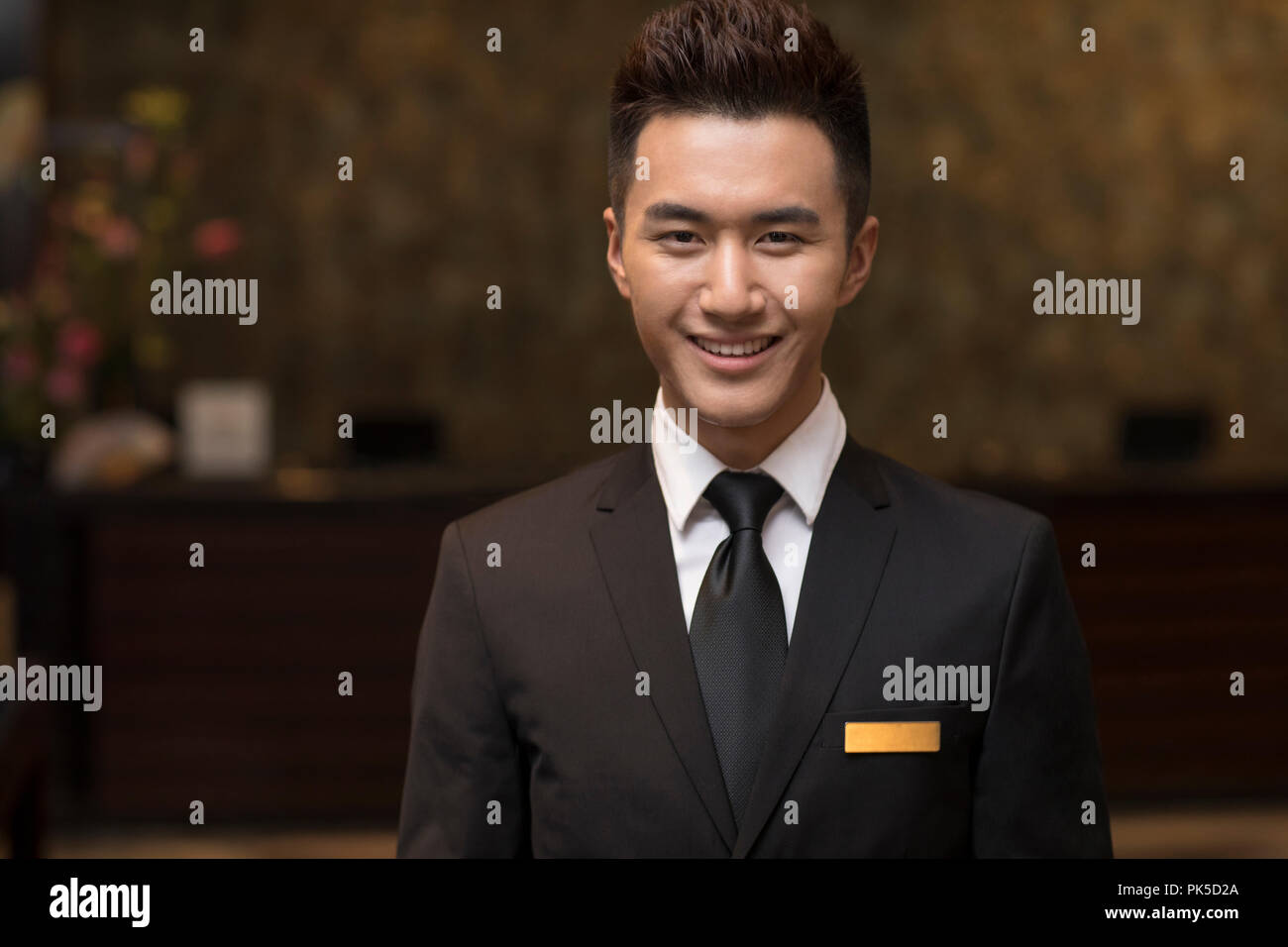 Portrait of confident hotel receptionist Stock Photo - Alamy