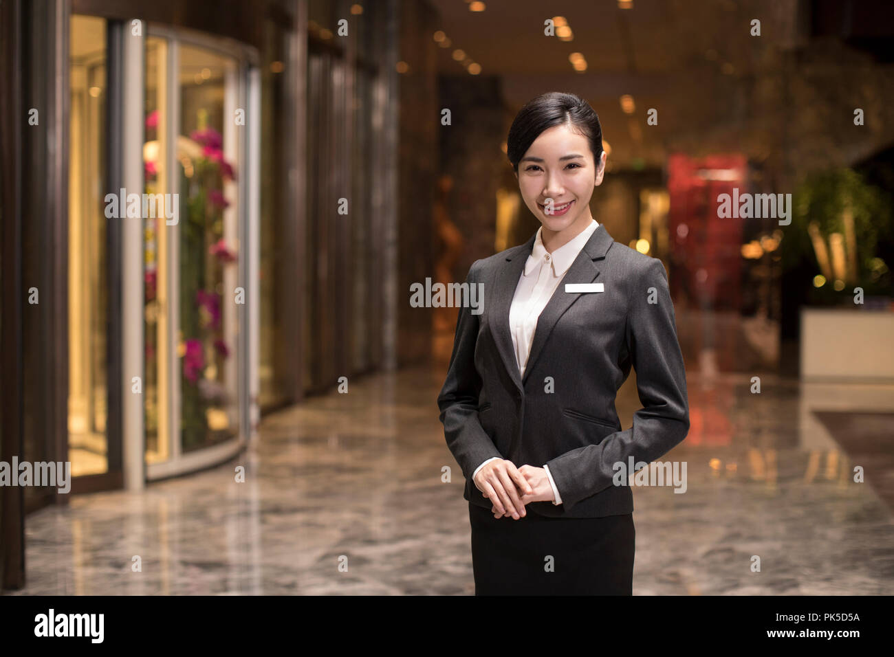 Portrait of confident hotel receptionist Stock Photo - Alamy