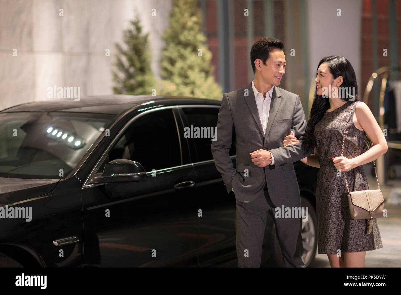 Cheerful young couple arriving at hotel by car Stock Photo - Alamy