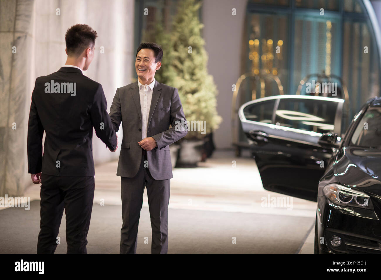 Confident business person shaking hands outdoors Stock Photo - Alamy