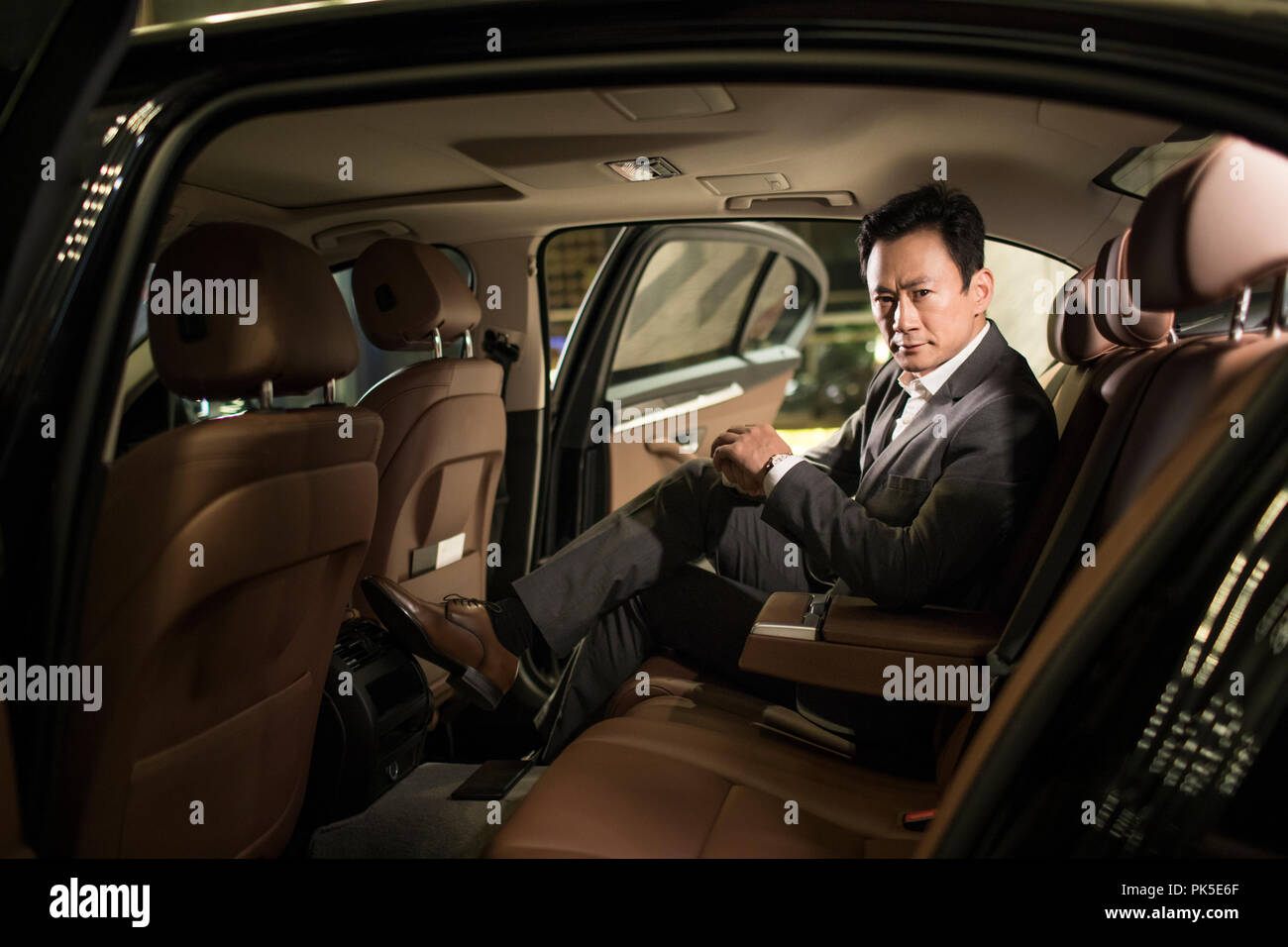 Successful businessman sitting in car back seat Stock Photo - Alamy
