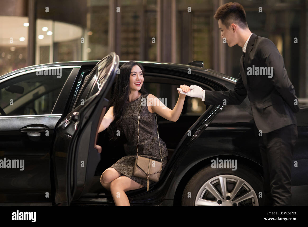 Young woman getting out of a car Stock Photo - Alamy