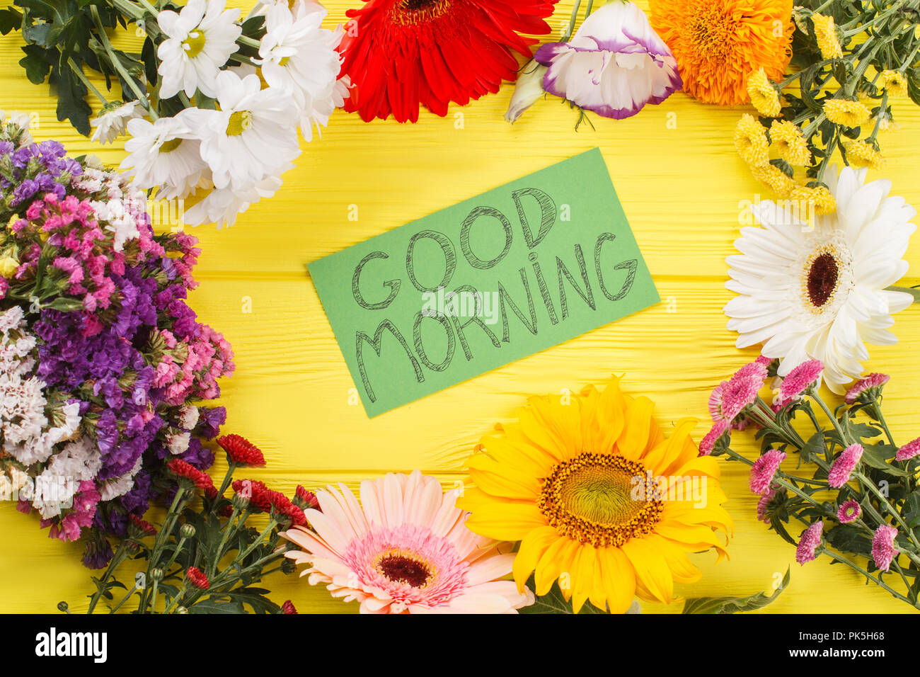 Lovely good morning wish and flowers. Yellow wooden desk background ...