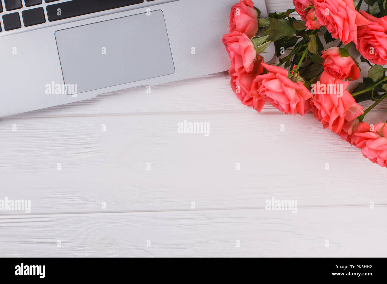 Laptop pc and rose flowers. White wood background Stock Photo - Alamy