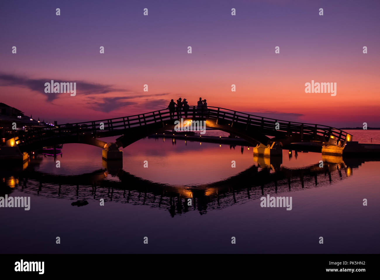 Silhouettes and reflections as tourists enjoying a beautiful sunset ...