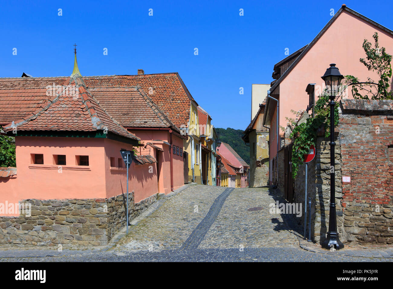 A traditional colorful cobbled street in the Old Town of Sighisoara in ...