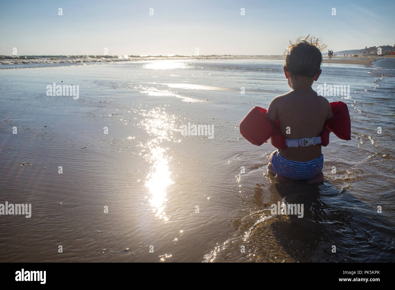 Little boy enjoying on the beach. He wears float life jacket Stock ...