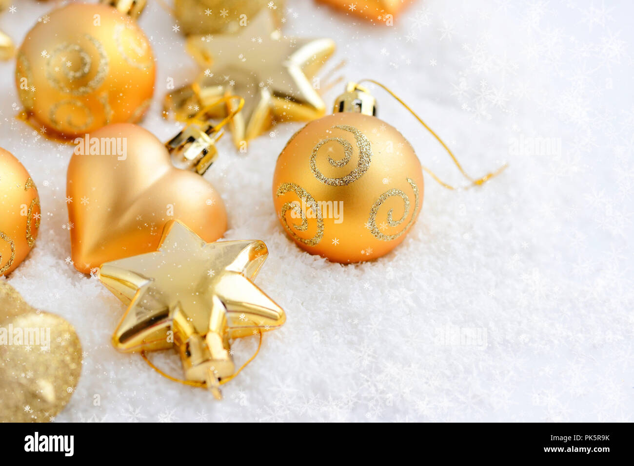 Christmas gold ornaments on the snow. Festive Christmas background ...