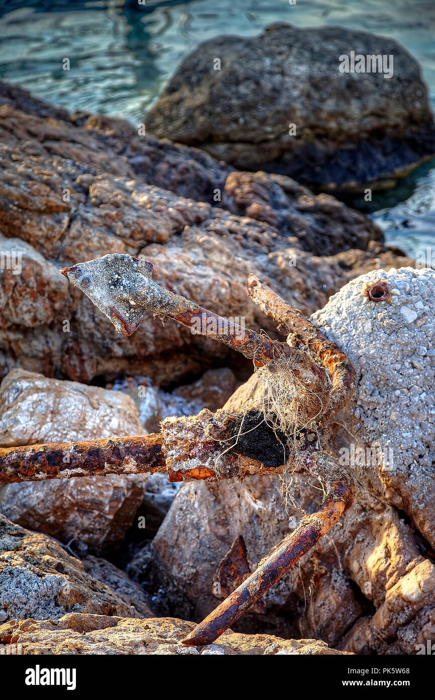 Rusty old anchor abandoned on the rocks. Isolated. Stock Image Stock ...