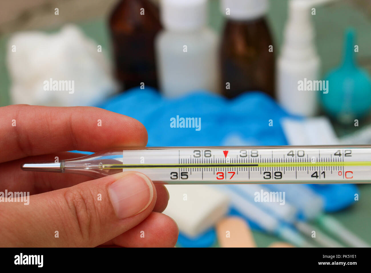 Hand holds thermometer. Body temperature of 38.4 C Stock Photo - Alamy