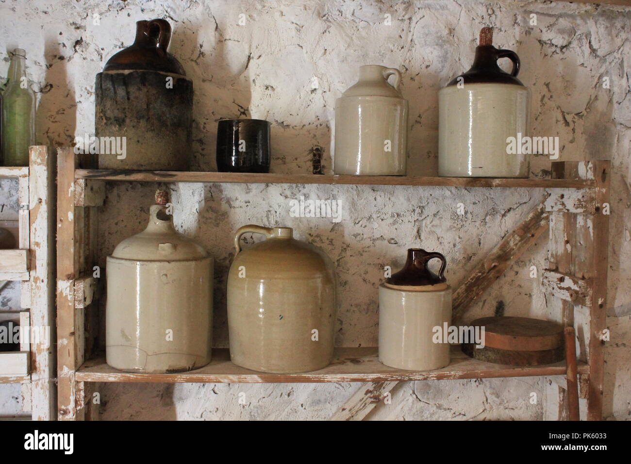 Antique stoneware crockery and storage bottle containers on a late ...