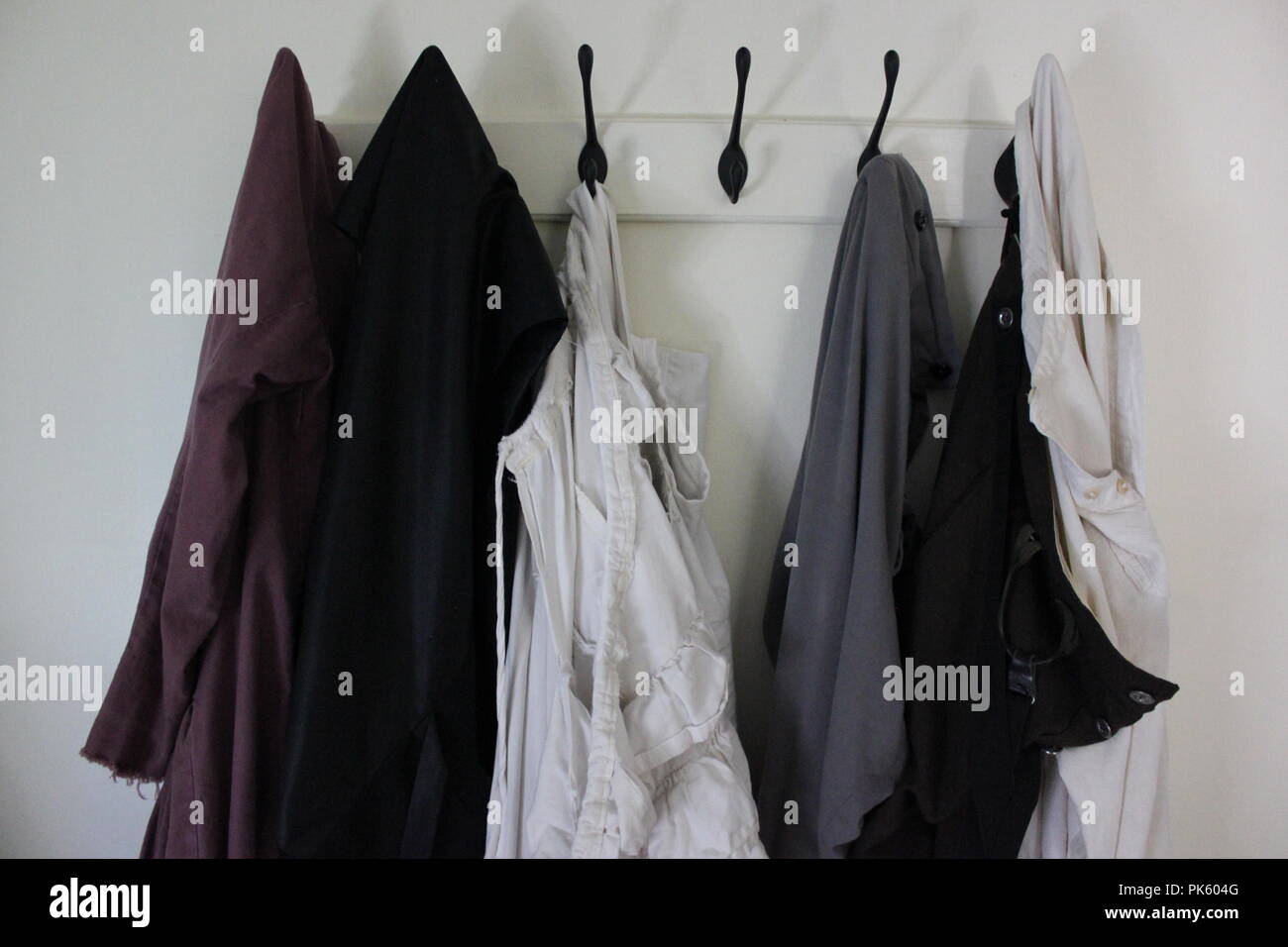 Vintage farm clothes hanging on hooks inside the farmhouse on a late ...