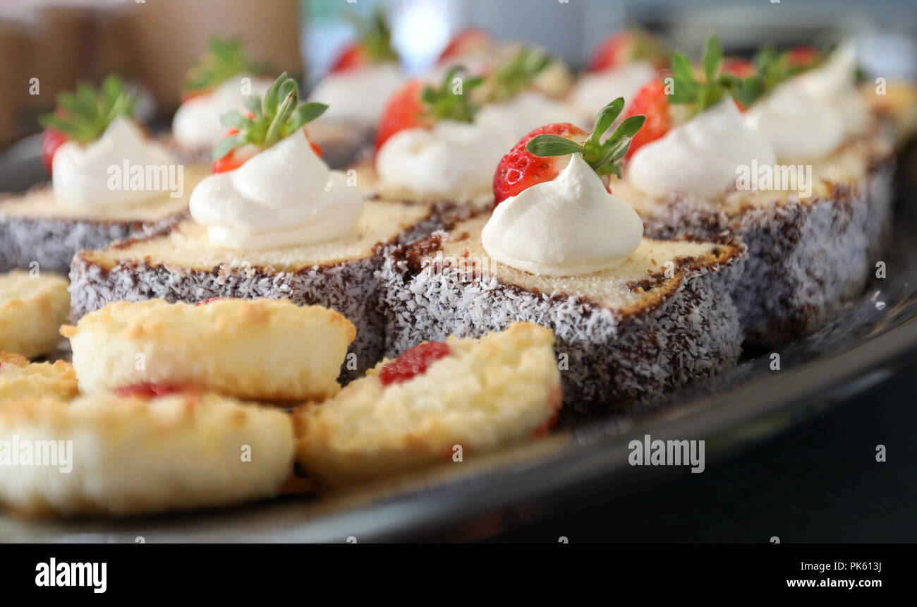 Tea party. close up shot of chocolate lamington cakes with a dollop of ...