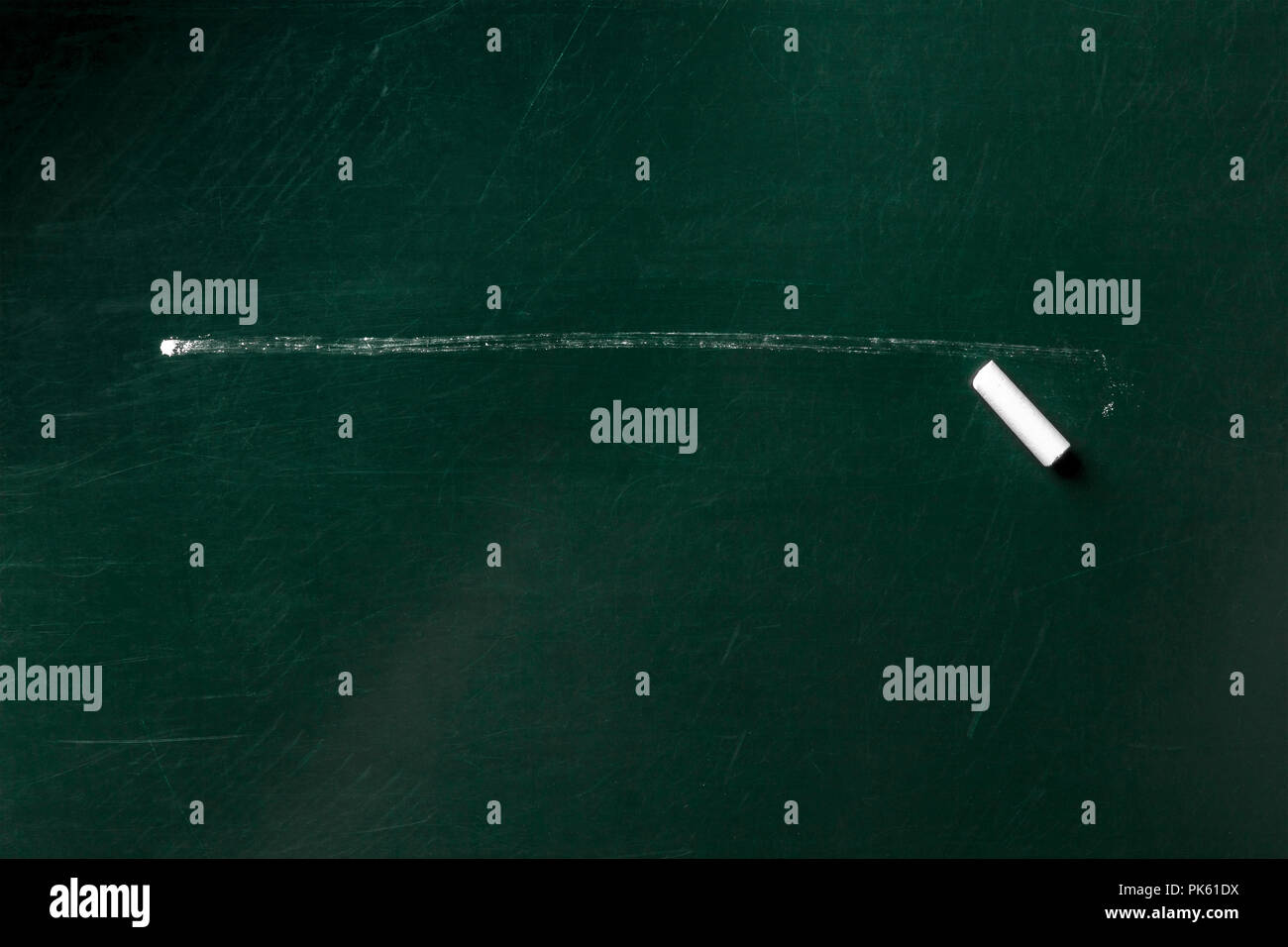 A photo of a line with a piece of chalk on a dark blackboard with copy ...