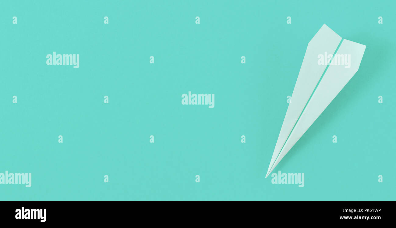 Flat lay colorful paper plane on pastel turquoise background with ...