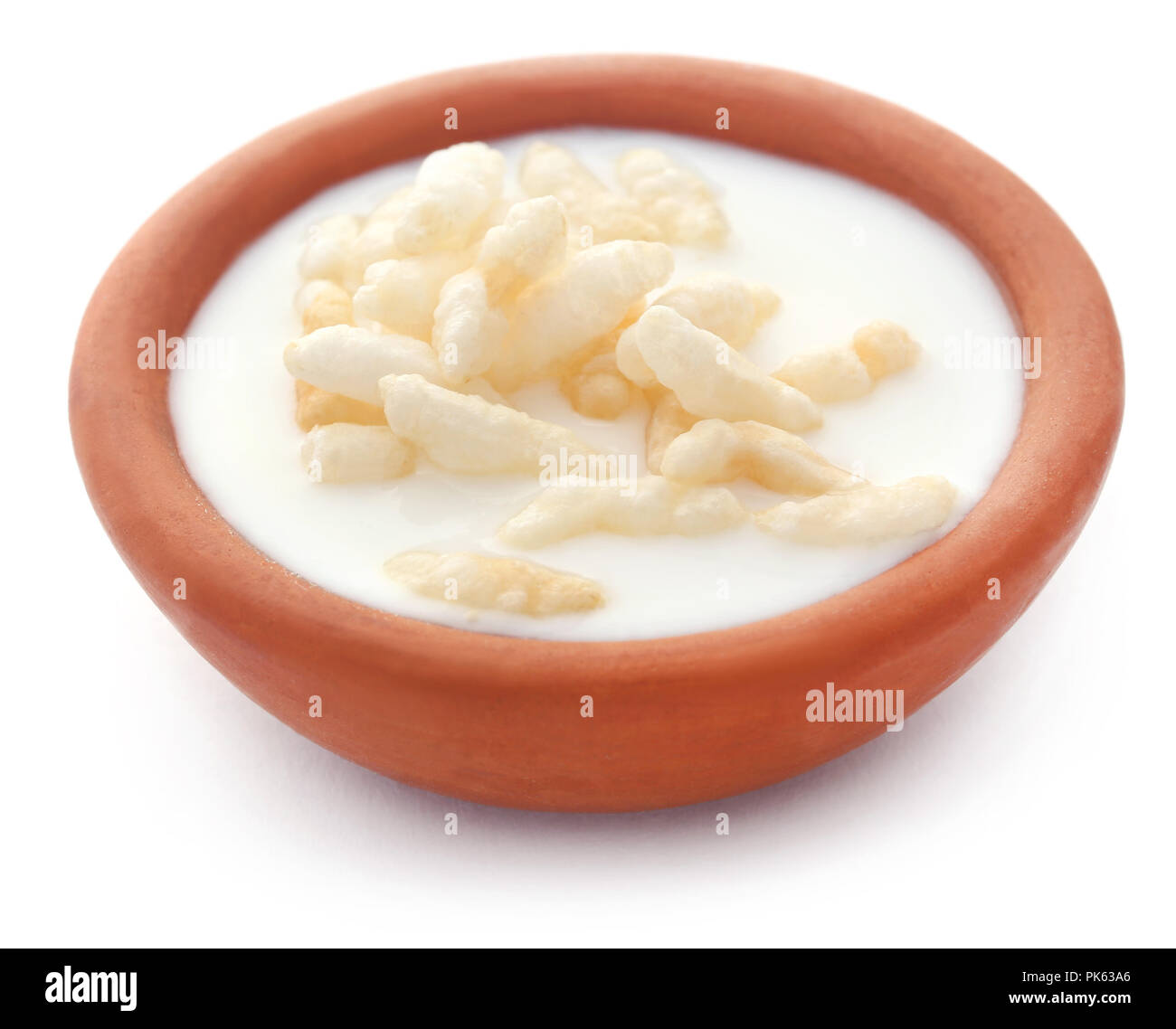 Fresh milk in a clay pottery with puffed rice over white background ...