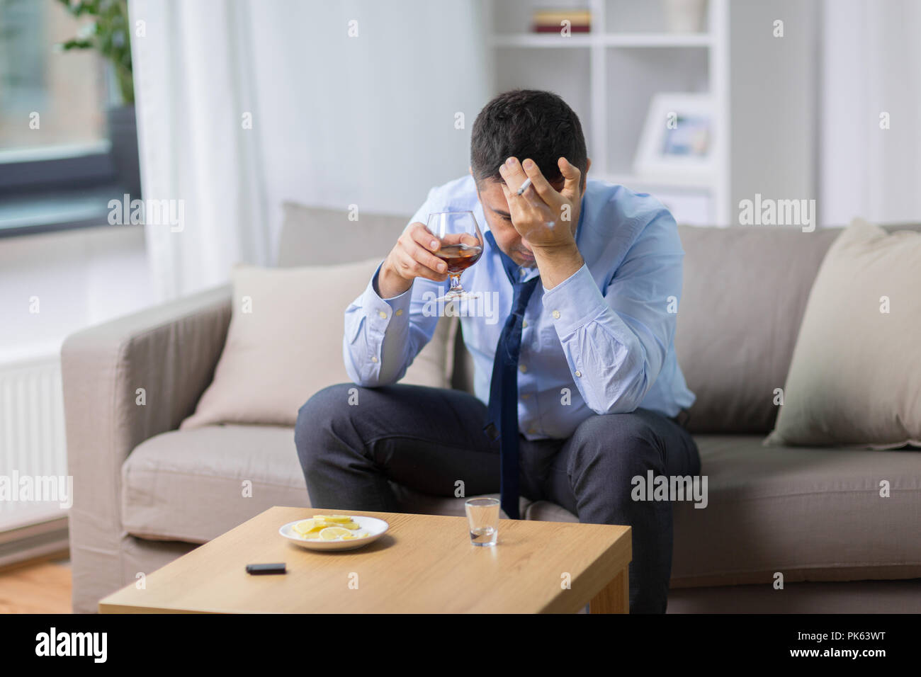 drunk man drinking alcohol and smoking cigarette Stock Photo - Alamy
