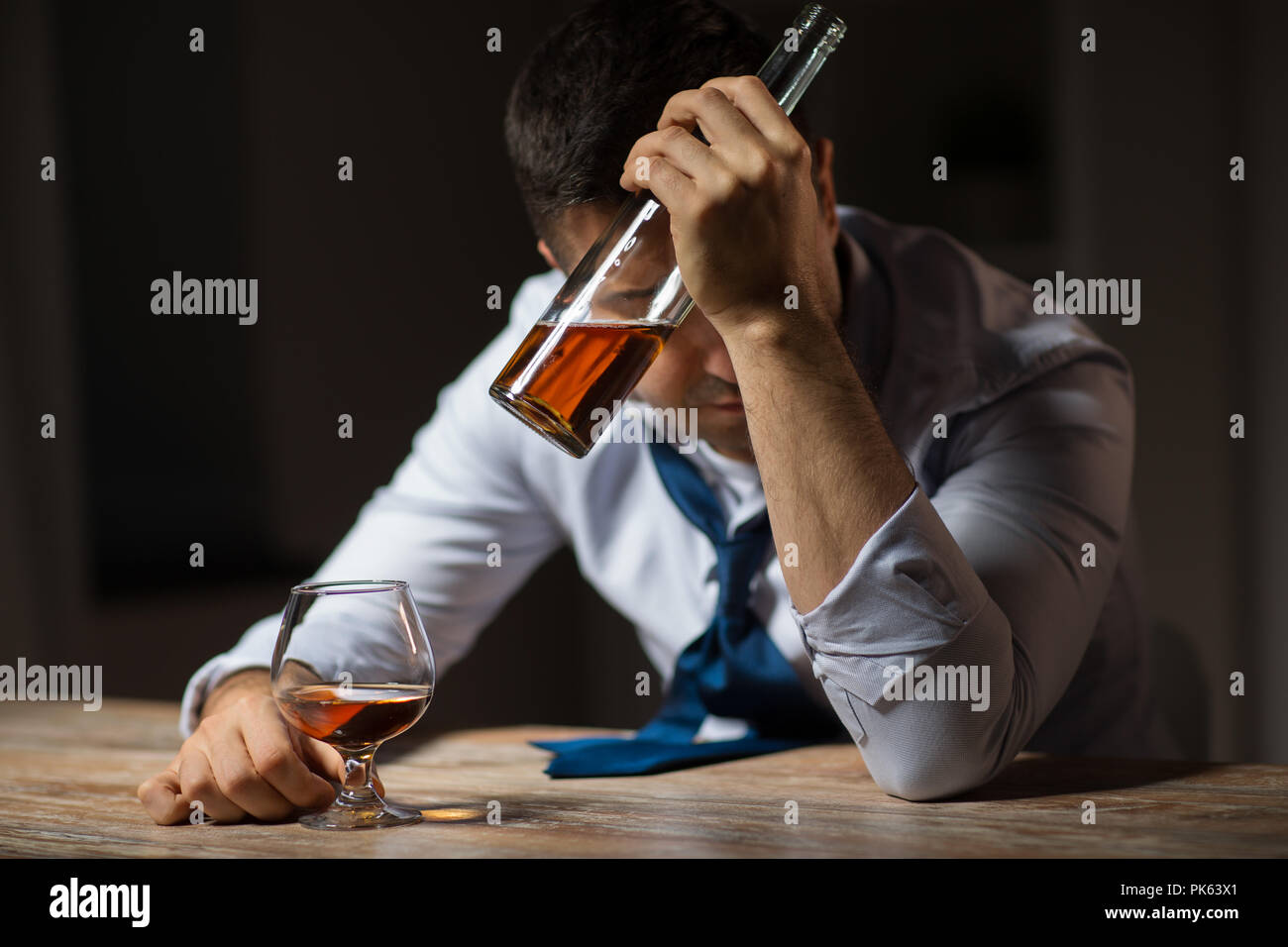 drunk man drinking alcohol at table at night Stock Photo - Alamy