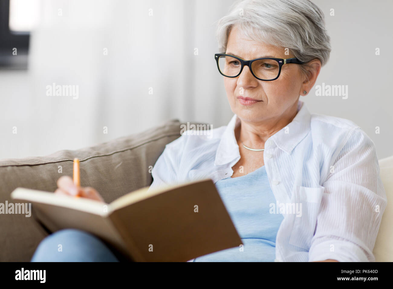 Older woman taking notes home hi-res stock photography and images - Alamy