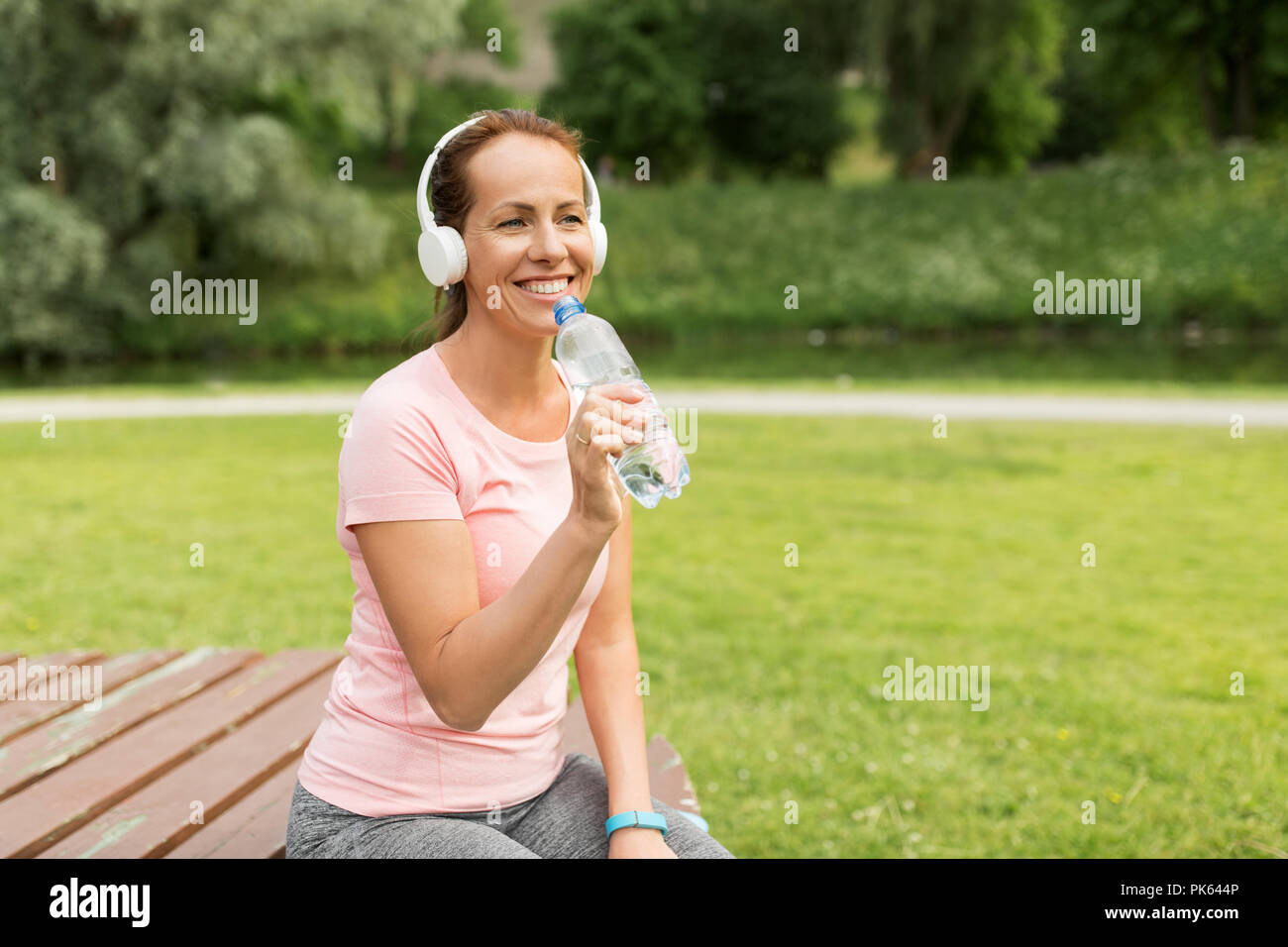 woman in headphones drinking water in park Stock Photo - Alamy