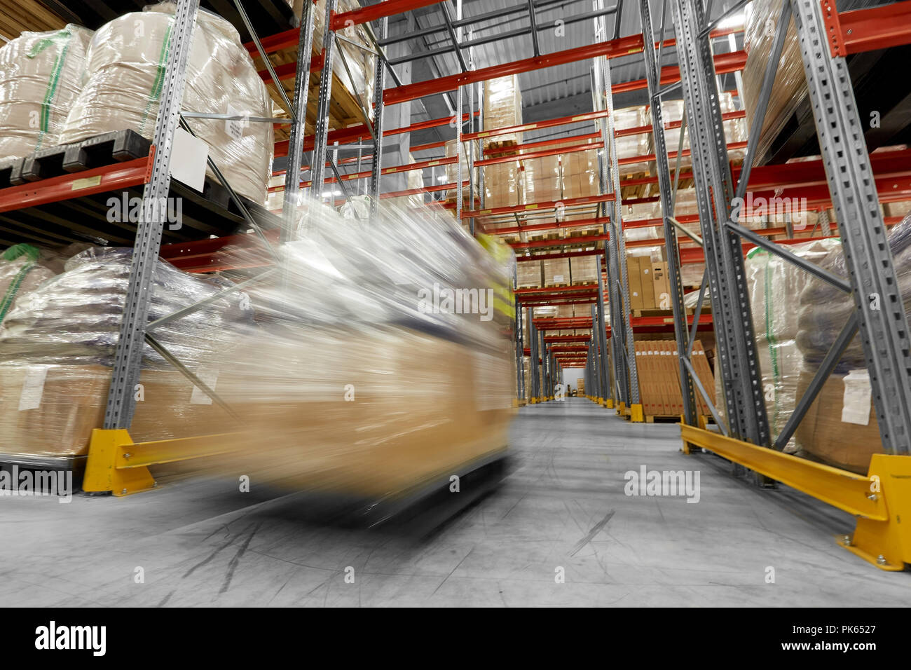 worker carrying loader with goods at warehouse Stock Photo - Alamy