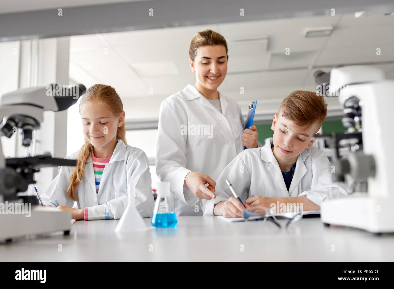teacher and students studying chemistry at school Stock Photo - Alamy