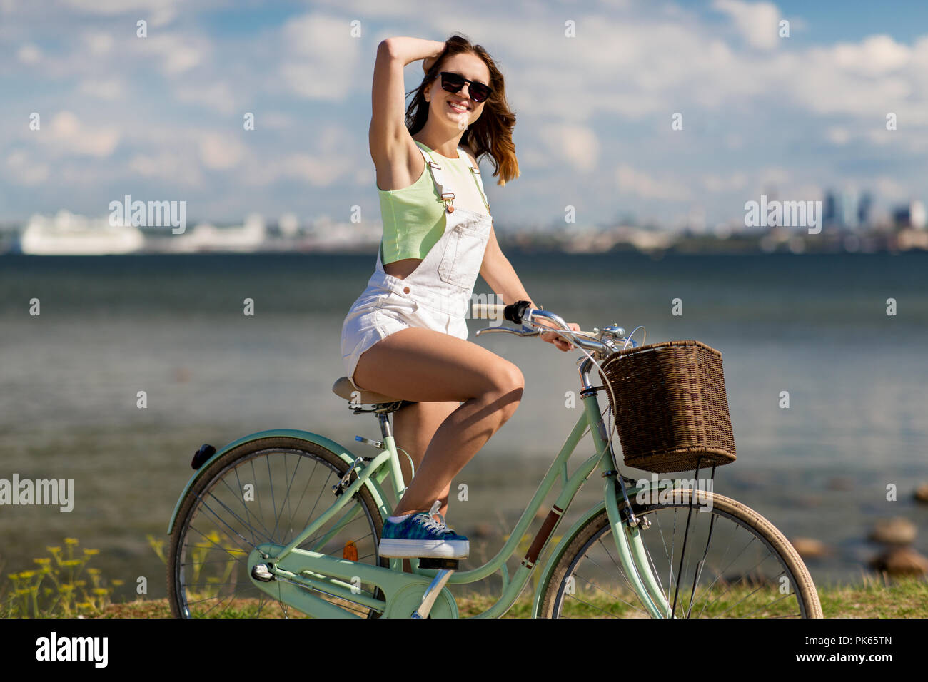 happy young woman riding fixie bicycle at seaside Stock Photo - Alamy