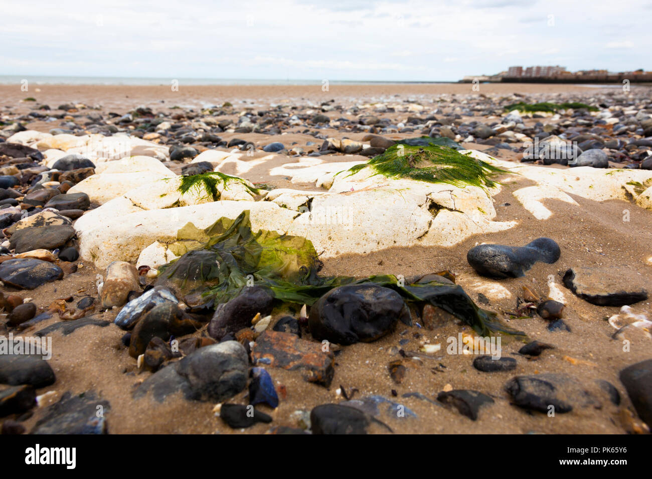 Exposed chalk wave-cut platform and pebbles on an otherwise apparently ...