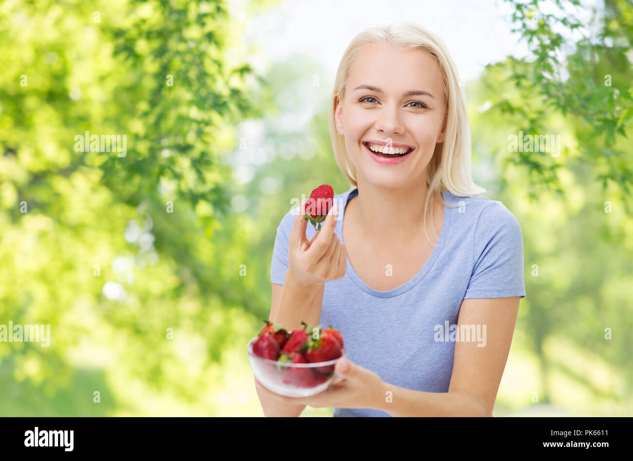 happy smiling woman eating strawberry Stock Photo - Alamy