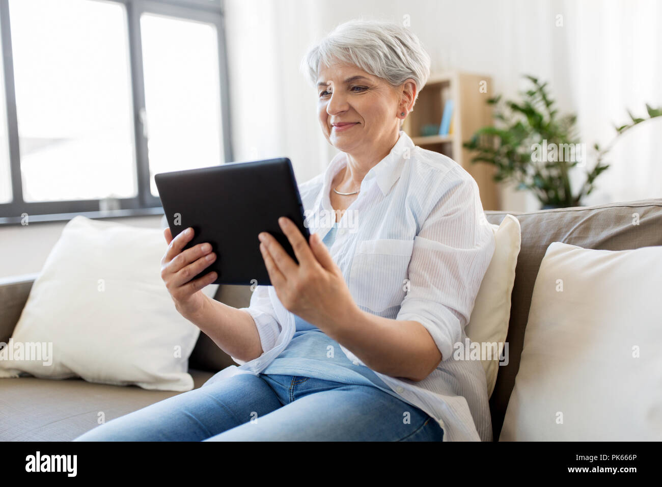 happy senior woman with tablet pc at home Stock Photo - Alamy